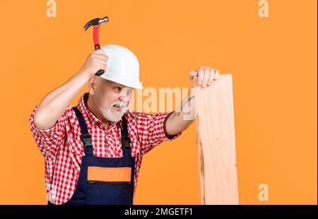 busy old aged man woodworker in helmet on yellow background Stock Photo ...