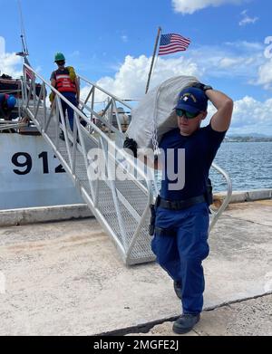 The crew of the Coast Guard Cutter Legare stands on the flight deck of ...