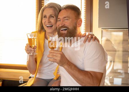 Married couple looking enjoyed and happy while having a glass of wine ...