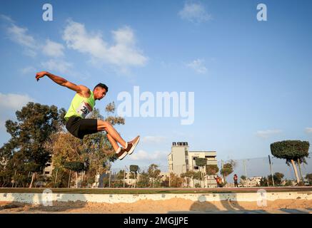 A Palestinian athlete competes in the long jump during the Central ...