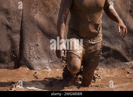 Mud race runners during extreme obstacle race Stock Photo - Alamy
