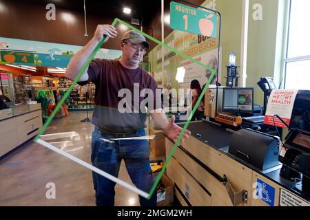 Martin Ragain, of Wichita, Kan., installs a plexiglass shield on a ...