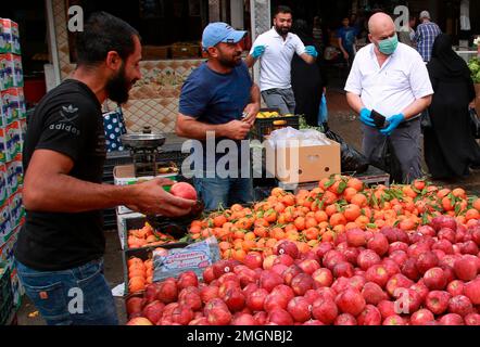 Iraqis buy groceries in downtown Baghdad, Iraq Monday, March 16, 2020 ...