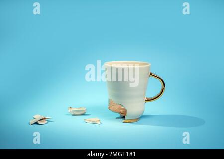 Broken tea cup isolated on yellow background. Cracked coffee mug and ...