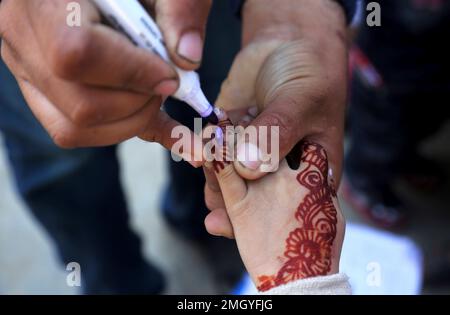 A health worker marks the finger of a child with ink during a national ...