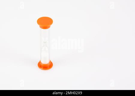 hourglass timer in plastic orange in grey background with white sand ...