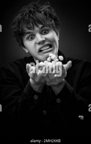 portrait of crazy young man throwing up popcorn Stock Photo - Alamy