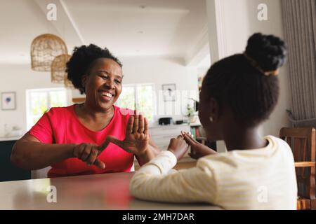 Happy african american grandmother and deaf granddaughter using sign ...