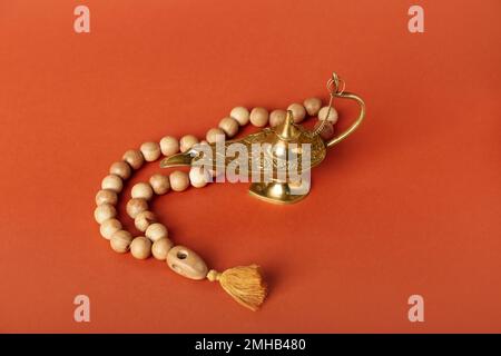 Aladdin lamp of wishes and prayer beads for Ramadan on dark background ...