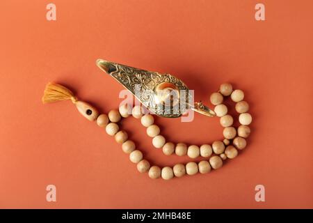 Aladdin lamp of wishes and prayer beads for Ramadan on dark background ...