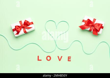 Heart made of turquoise satin ribbon on pink background. Valentine's ...