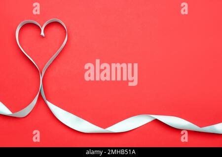 Heart made of turquoise satin ribbon on pink background. Valentine's ...