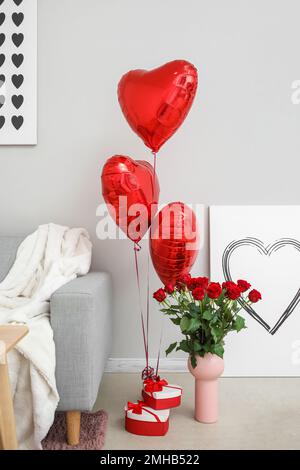 Vase with red roses and balloons for Valentine's Day in living room ...