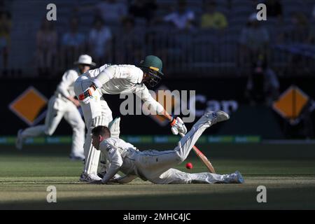 Australia's Mitchell Starc, left, reaches for the crease as New Zealand ...