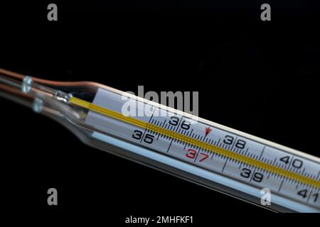 Old glass thermometer on a dark isolated background Stock Photo - Alamy