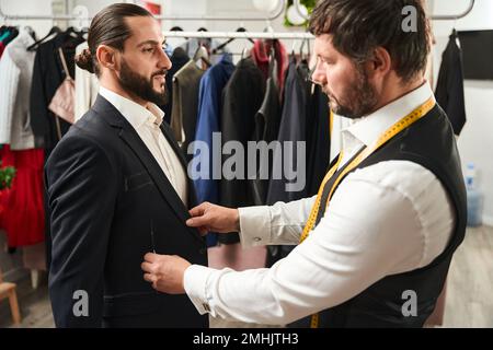 Professional clothier marking tucks on client garment Stock Photo - Alamy