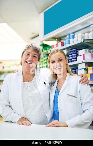 Two women pharmacist smiling confident writing on document at pharmacy ...