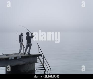 Rod fishermen on a jetty in the River Cree estuary looking from the ...