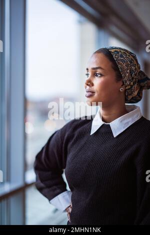 A woman is looking through the open window of a parked car, resting her ...