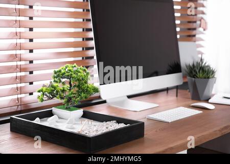 Modern workplace with beautiful miniature zen garden and computer in ...
