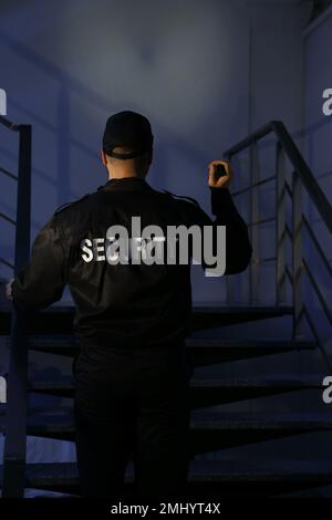Male security guard with flashlight going up stairs in darkness Stock ...