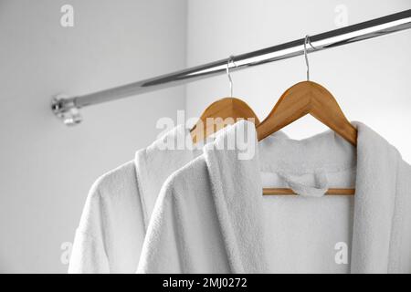 Soft comfortable bathrobes hanging on rack in closet Stock Photo - Alamy