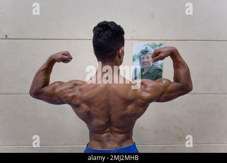 A Palestinian bodybuilder prepares for the competitions during the ...