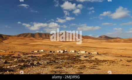 Island interior, barren landscape, reddish brown hills, building ruins ...