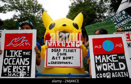 An environmental activist, wearing a "Pikachu" costume, poses during a ...