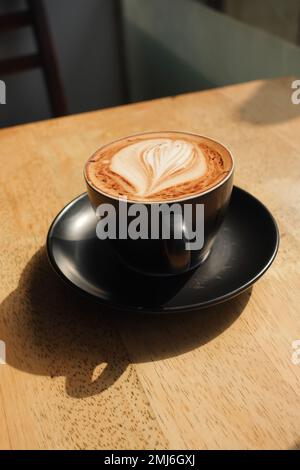 a cup of late coffee with flower shape design on top at cafe Stock ...