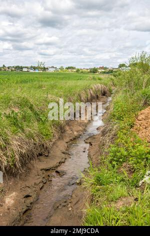 Ditch with a stream, small brook channel Stock Photo - Alamy