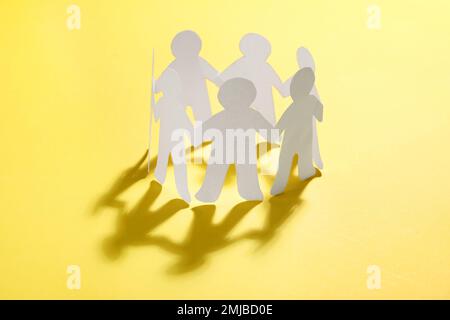 Paper people chain making circle on light blue background. Unity ...