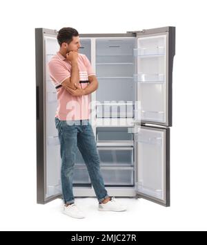 Man near empty refrigerator on white background Stock Photo - Alamy