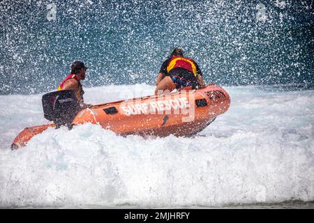 Surf Rescue volunteers power their zodiac RIB dinghy in the ocean off ...