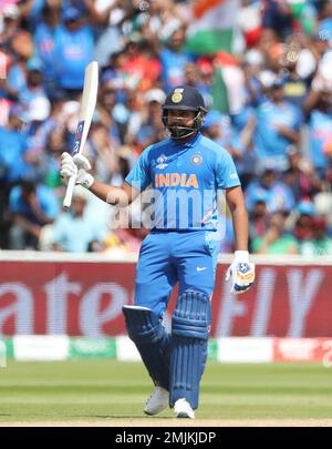 India's Rohit Sharma raises his bat and helmet to celebrate scoring a ...