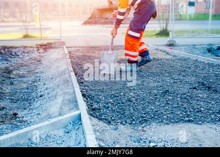 A new footpath is under construction as builders bring stone, levelling ...
