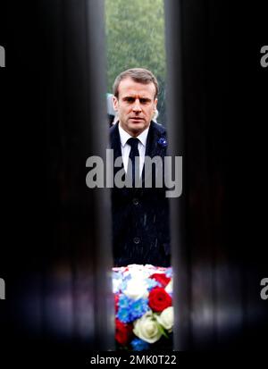 French President Emmanuel Macron lays a wreath of flowers during a ...