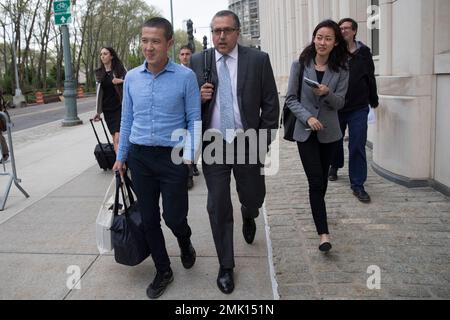 Roger Ng, center, a former Goldman Sachs banker, leaves federal court ...