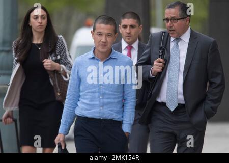 Roger Ng, center, a former Goldman Sachs banker, leaves federal court ...