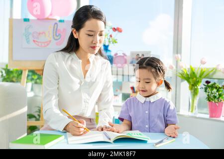The teacher taught the girl reading a book Stock Photo - Alamy