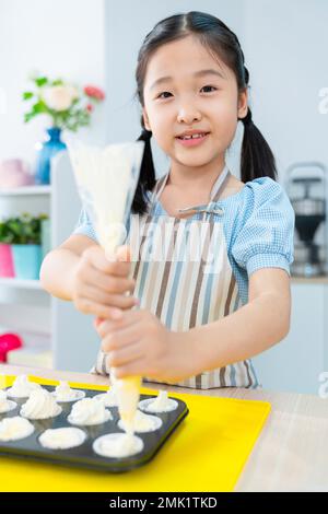 Happy little girl making cakes Stock Photo - Alamy
