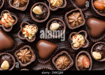 Different kinds of chocolates on colored table close-up. Top View and ...