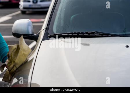 Man polishes car, using microfiber cloth. Man washing and wiping car in ...