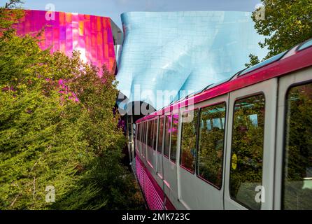 Monorail train comes out of the museum, Corrugated coloured exterior ...