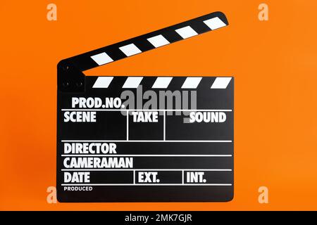 A clapper board on orange background with copy space. Cinema minimal ...