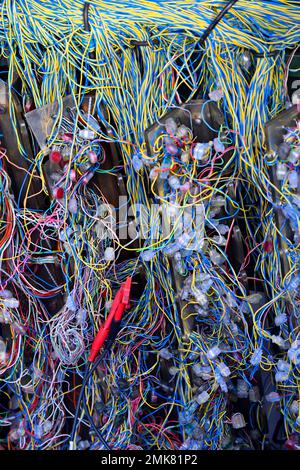 Telephone junction box with tangle of multicolour wires jointed to make ...