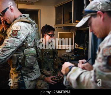 Explosive ordnance disposal technician uses a metal detector to scan ...