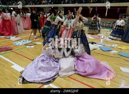South Korean seniors clad in traditional attire bow during a joint ...