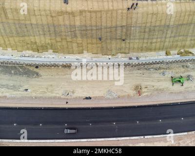 Mountain road constraction. Workers reinforce the slope over the new ...