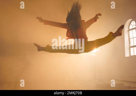 Image of biracial female modern dancer dancing in smoked interior Stock ...